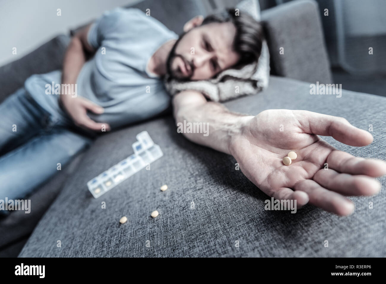 It is too much. Silhouette of sick man that lying on his sofa and ...
