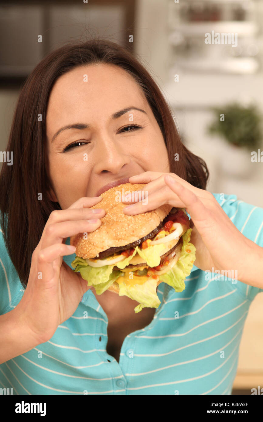 woman relish biting into her burger Stock Photo - Alamy