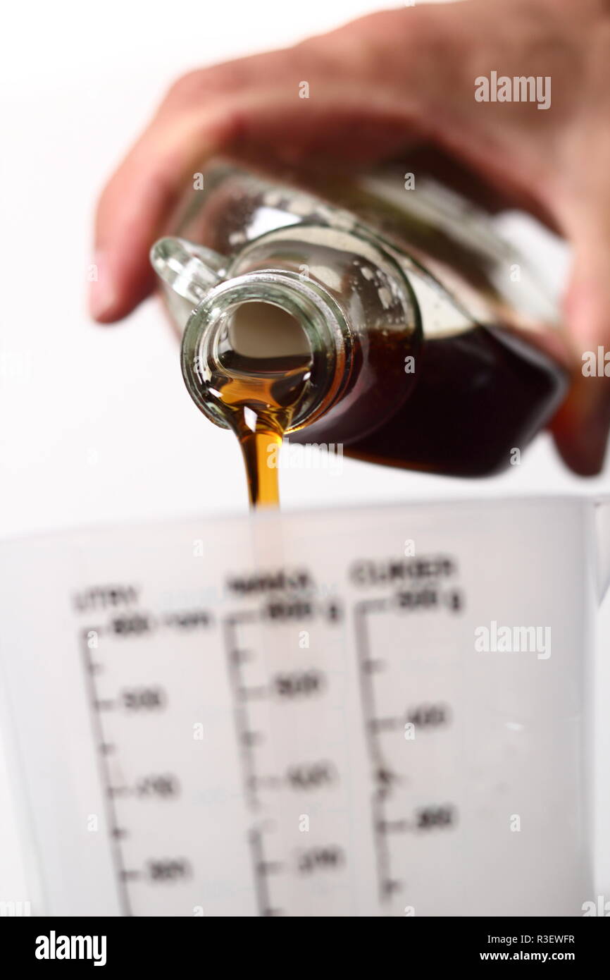 Pouring maple syrup into measuring cup Stock Photo - Alamy