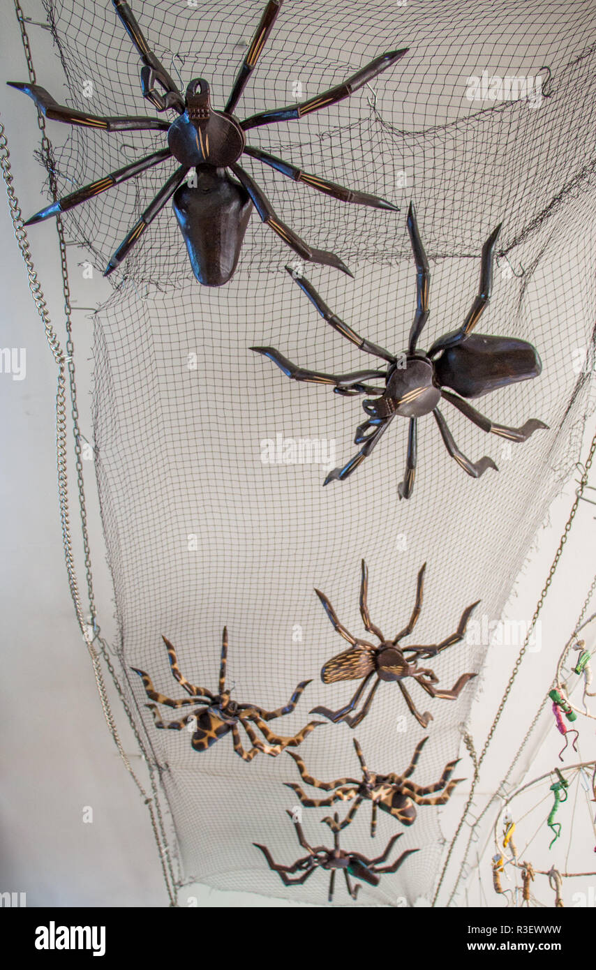 Steel spider figures on a black net on display Stock Photo - Alamy