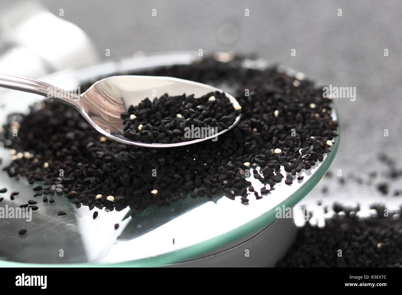 Weighing of black cumin seeds on kitchen scale Stock Photo - Alamy