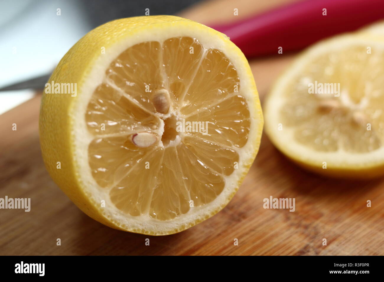 Cross section of lemon on wooden cutting board Stock Photo - Alamy