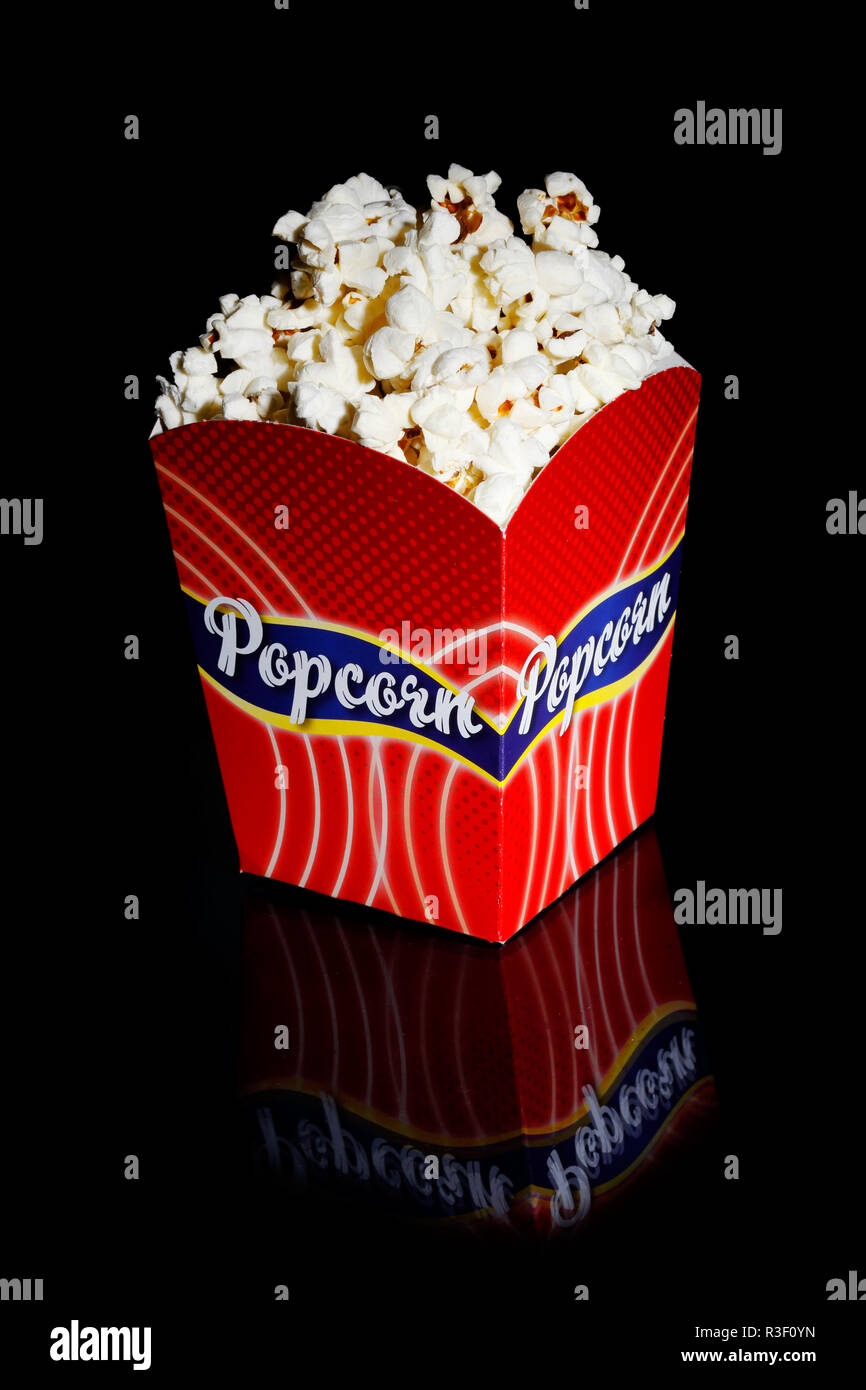 Filled red popcorn box on black background Stock Photo - Alamy