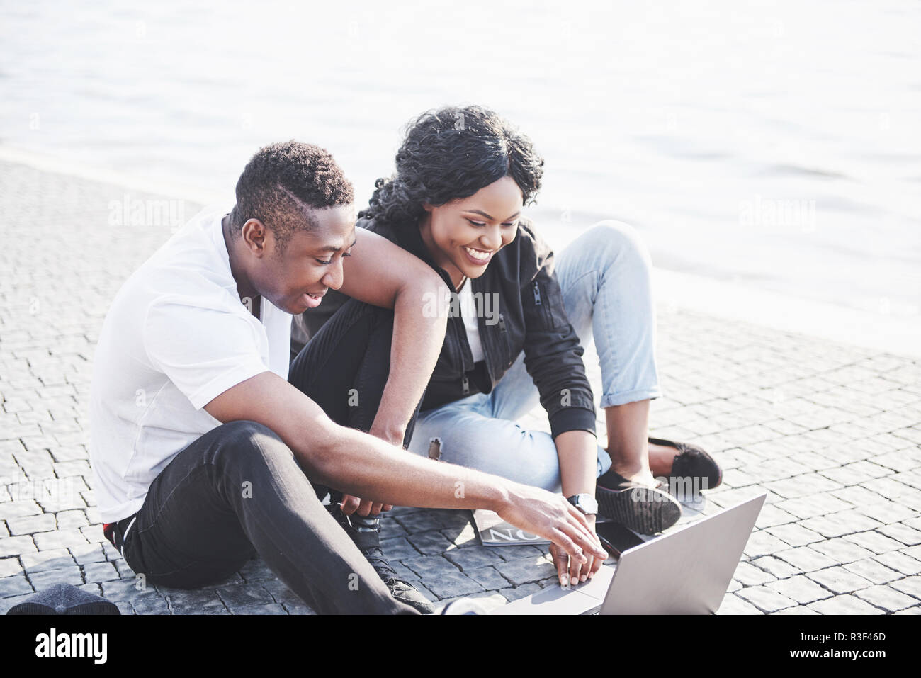 Two happy friends of students or business partners are sitting outdoors ...
