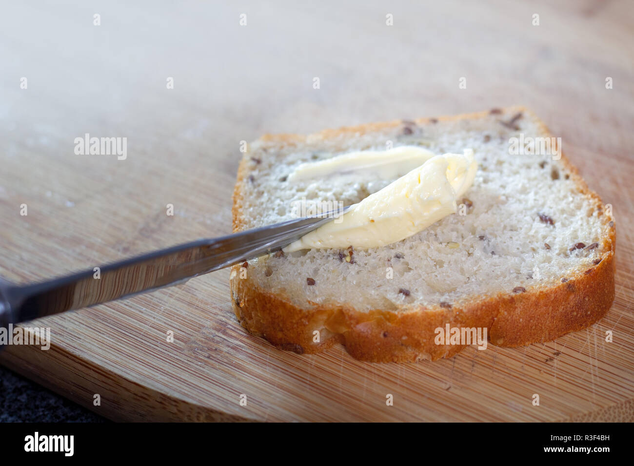 Spreading butter on bread with table knife Stock Photo - Alamy
