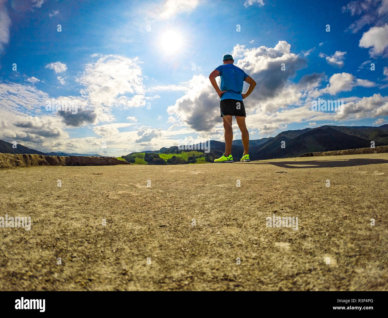 Male athlete runner resting at blue sky background Stock Photo - Alamy