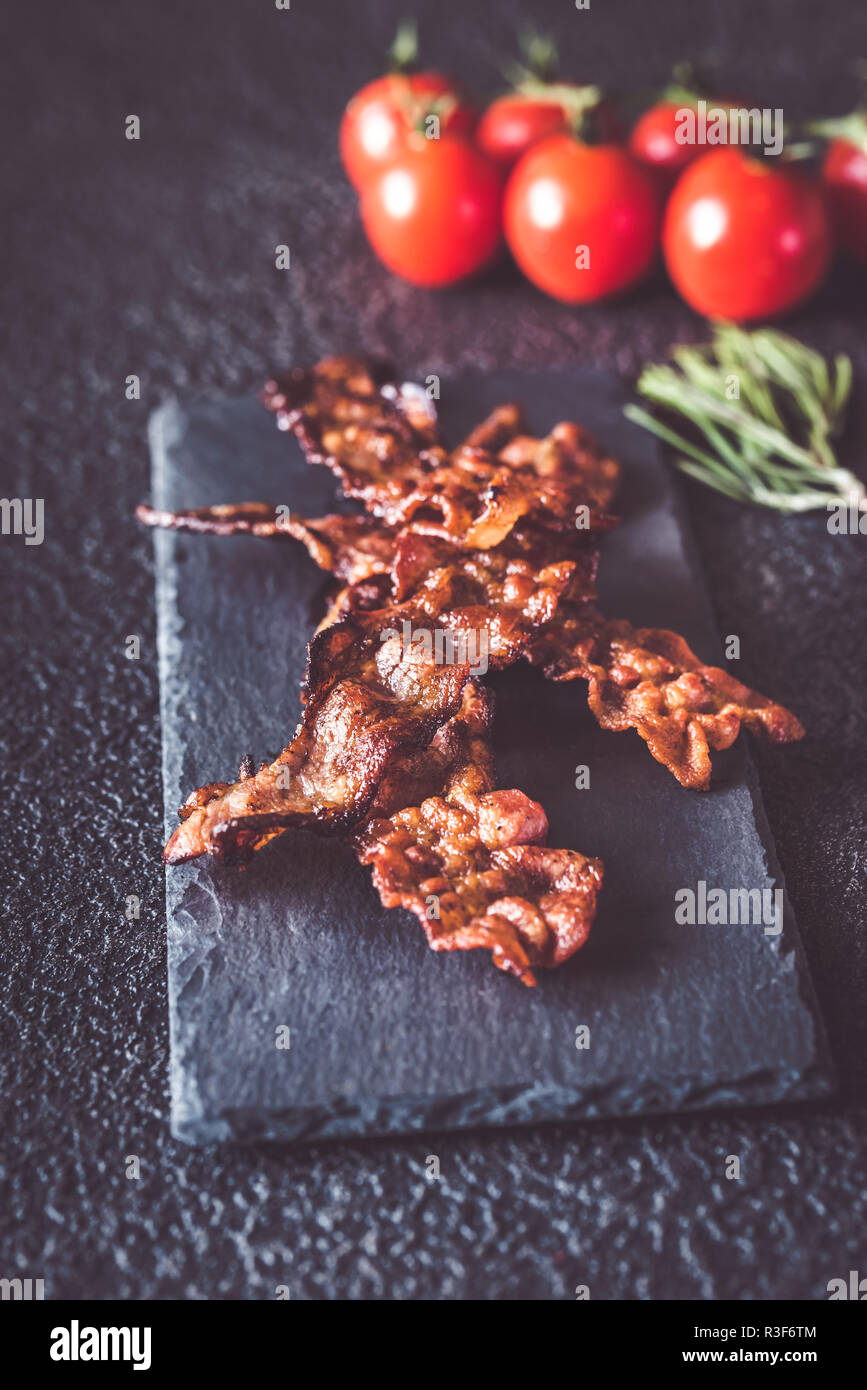 Fried bacon strips on the stone dark board Stock Photo - Alamy