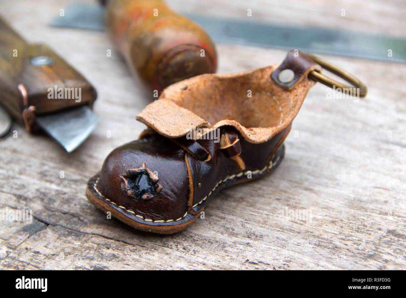 Colorfull leather key ring in the shape of old shoe on wooden ...