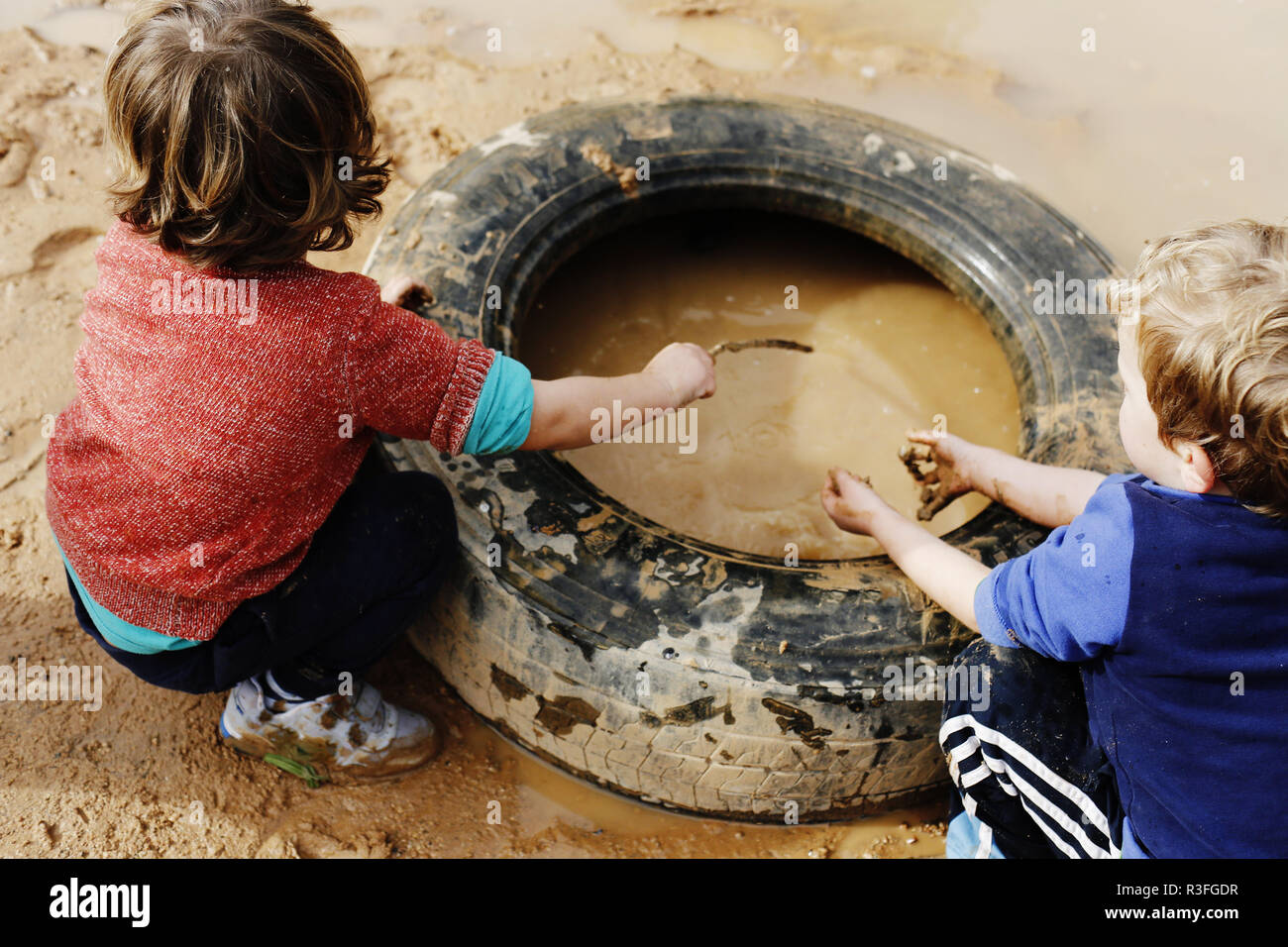 Children playing outdoors with mud Stock Photo - Alamy