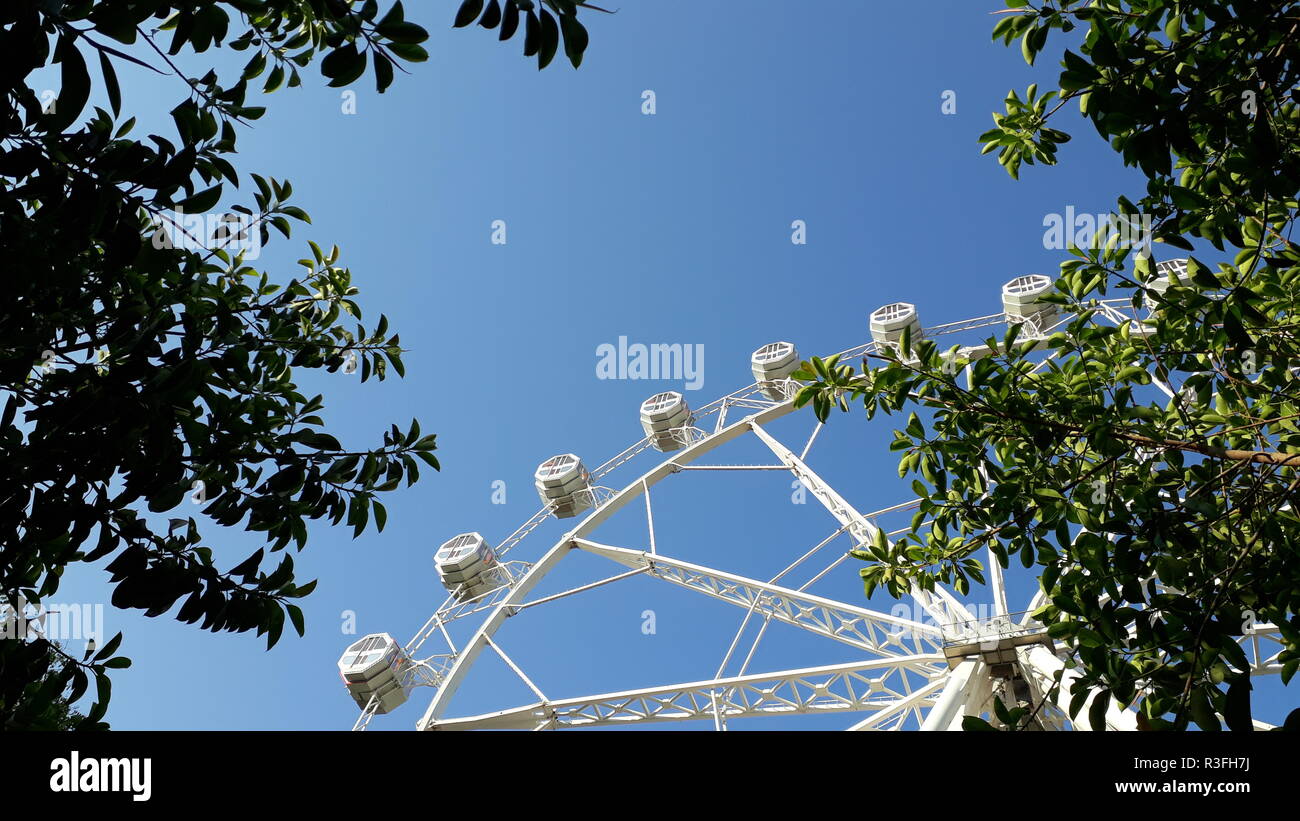 Modern ferris wheel at a fair in summer, with day blue sky background ...