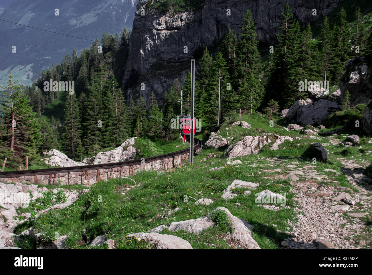 A red cable car train going up the mountain towards Pilatus Kulm ...