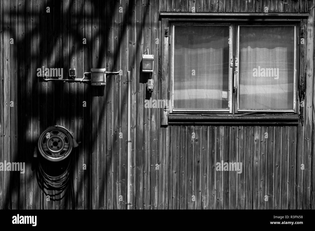 A facade with windows of a small wooden house in black and white, Kil ...