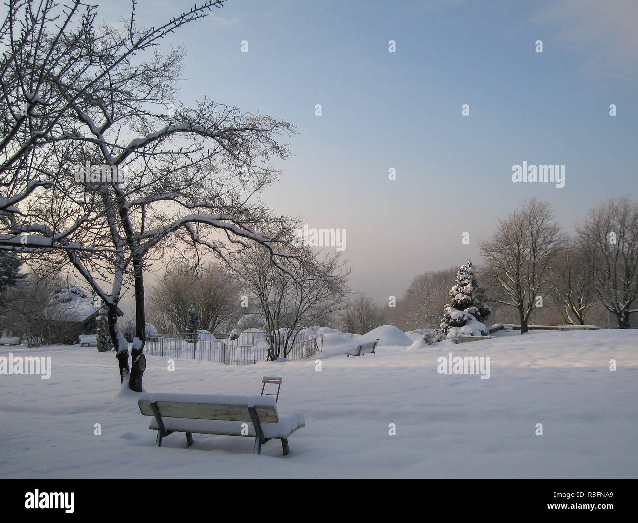 Beautiful peaceful scenic landscape covered in deep snow with a bench ...