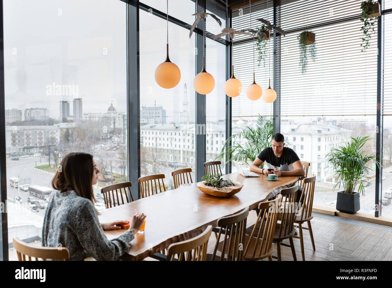 Two people a young man and a woman sitting at a big table, from ...