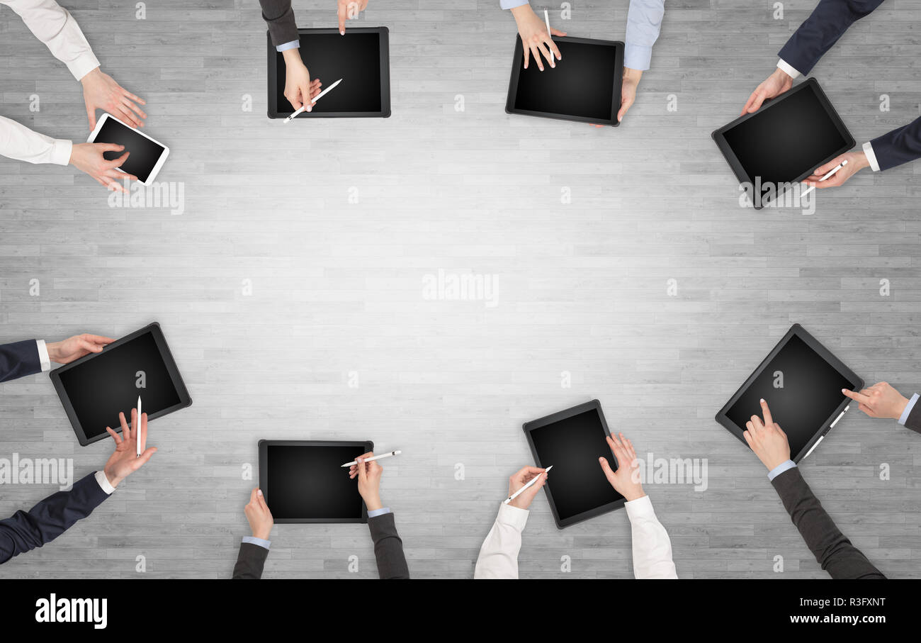 Group of people with devices in hands having desk discussion and making ...
