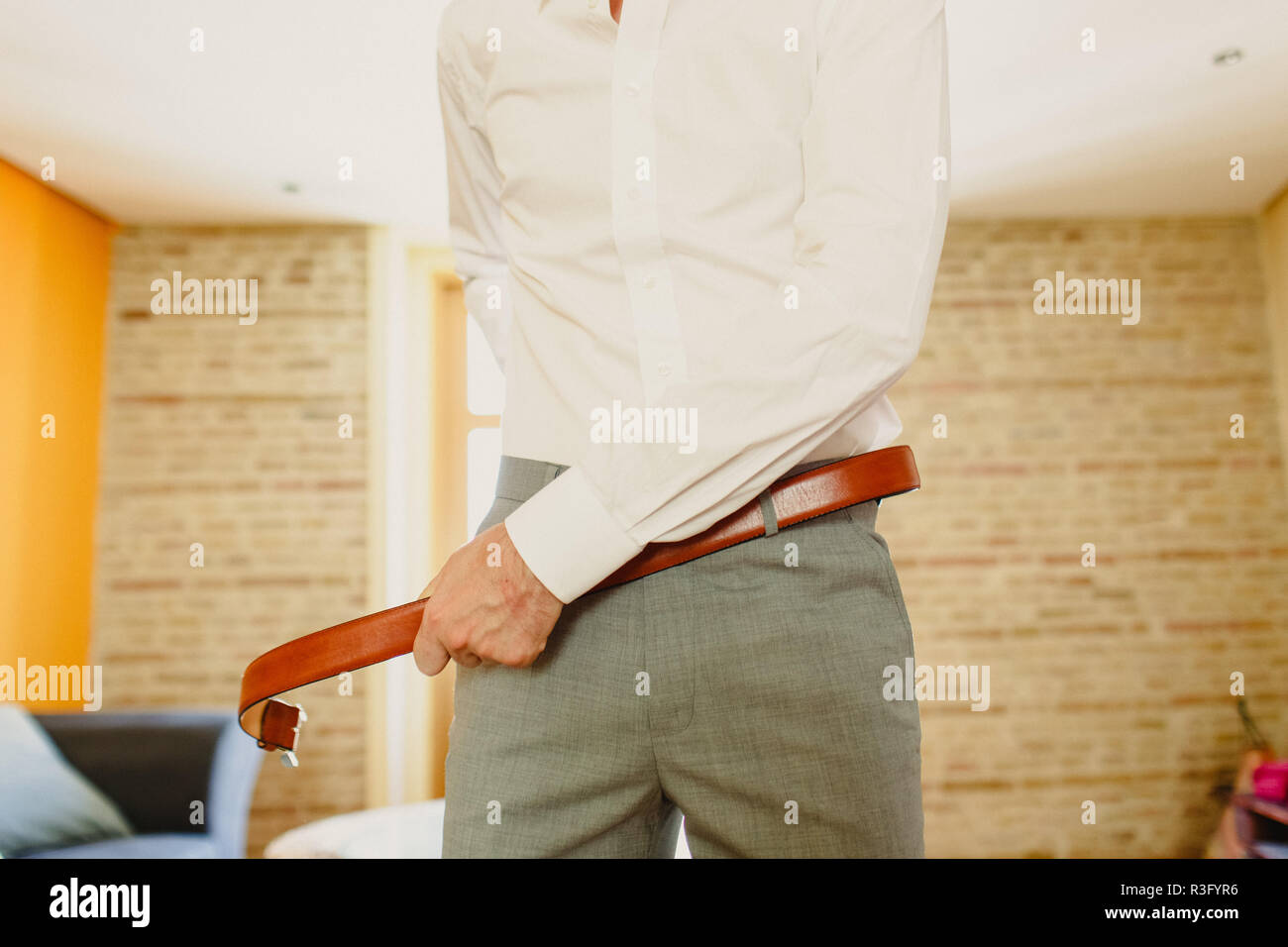 Man fastening his belt to his pants Stock Photo - Alamy