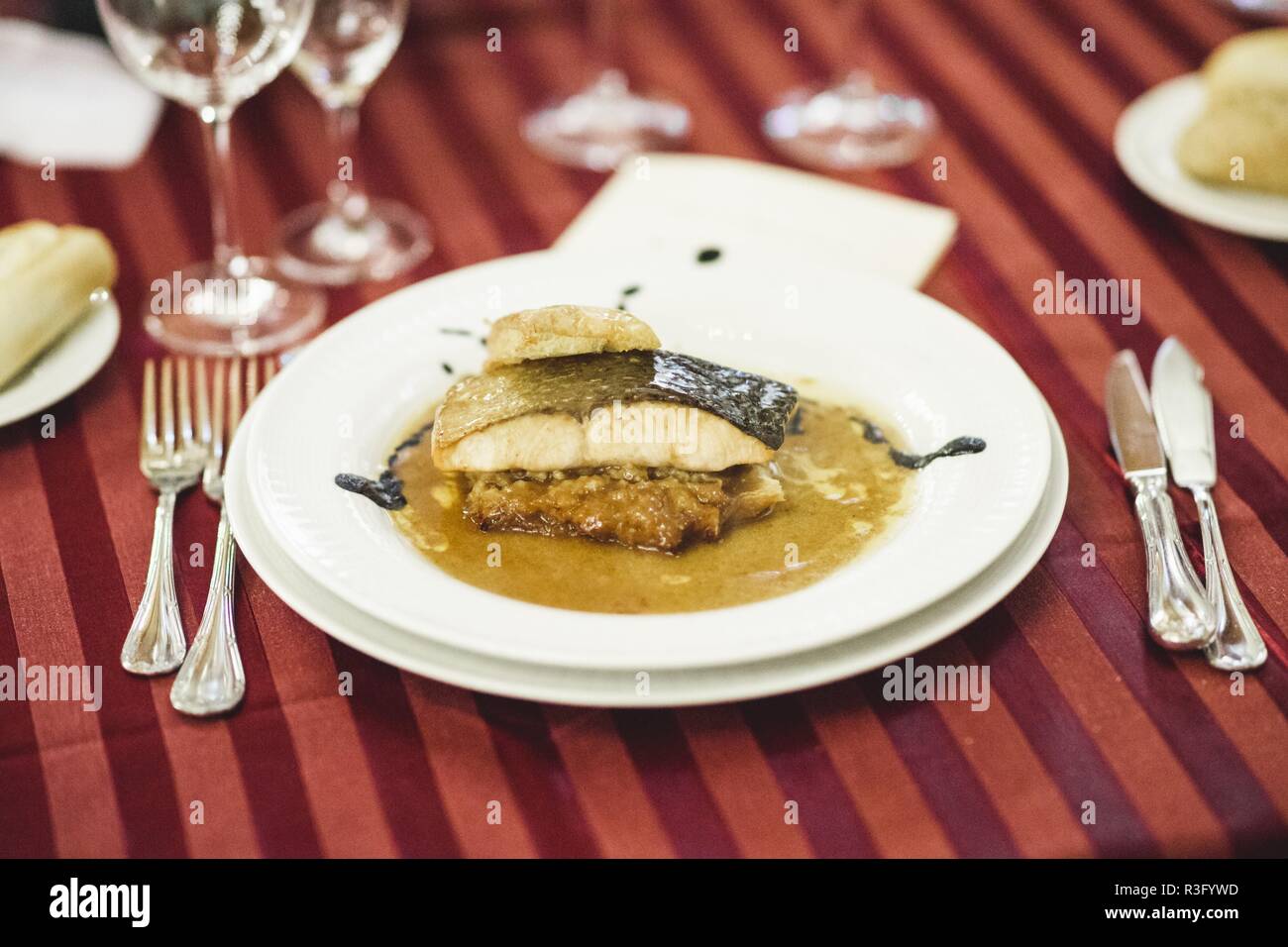 Hake dish with sauce served during a wedding Stock Photo - Alamy