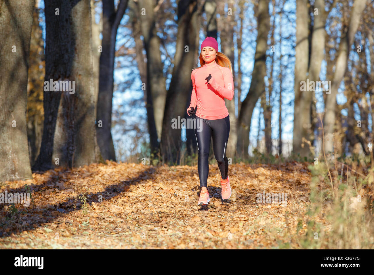 Young fitness woman jogging in autumn park in the morning. Attractive ...