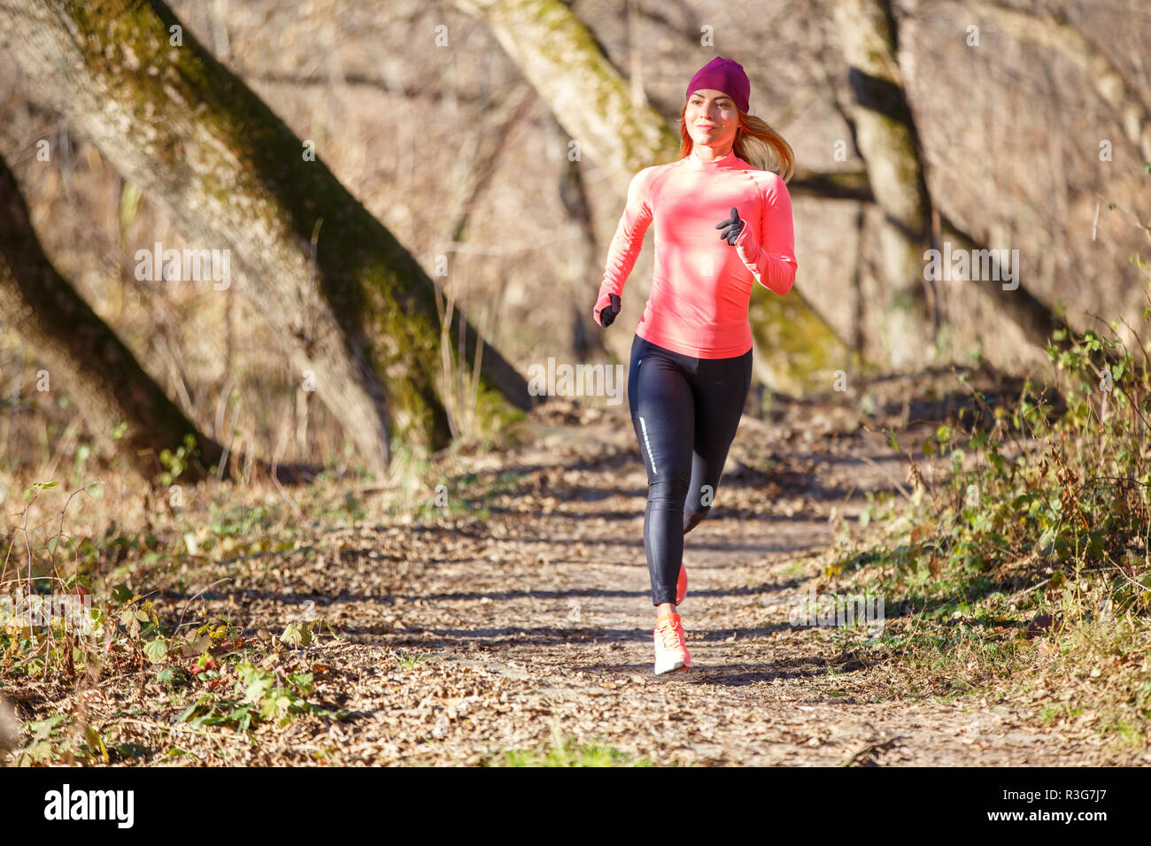 Young fitness woman jogging in autumn park in the morning. Attractive ...