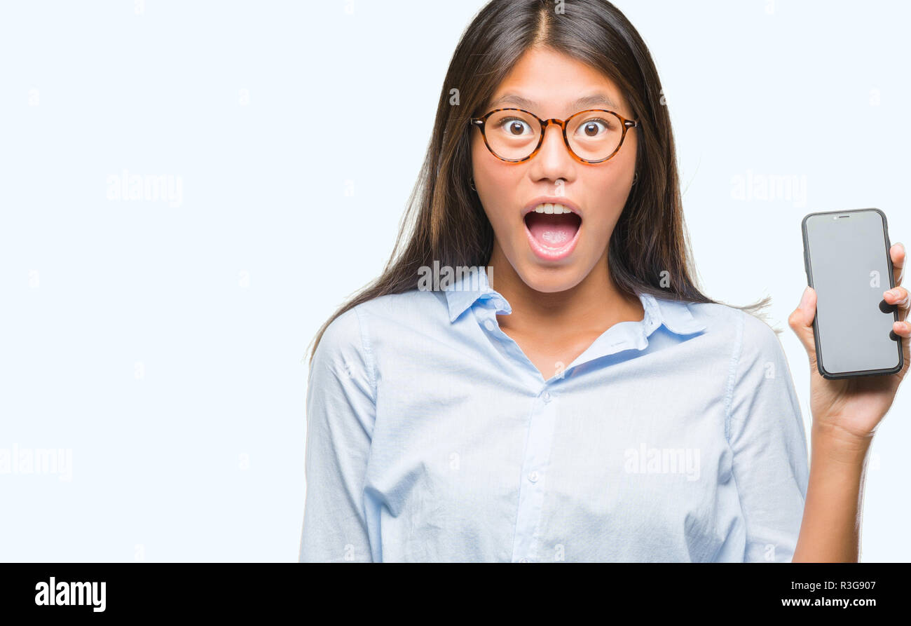Young asian woman showing smartphone blank screen over isolated ...
