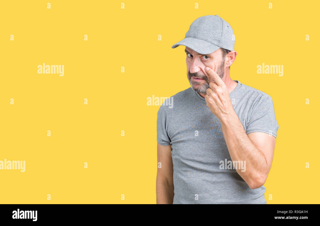 Handsome middle age hoary senior man wearing sport cap over isolated ...