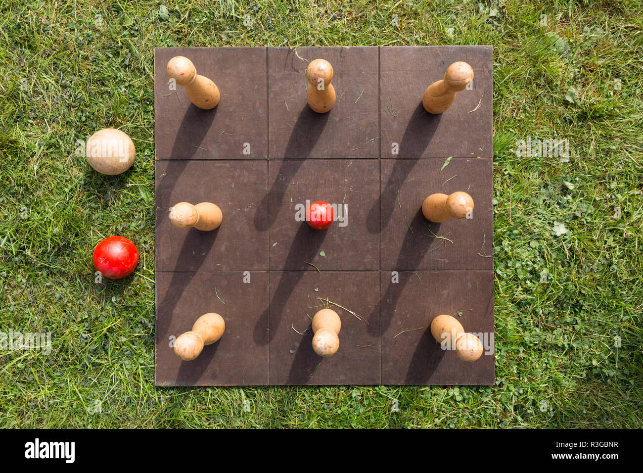 An old-fashioned traditional classic set of garden skittles on a board ...