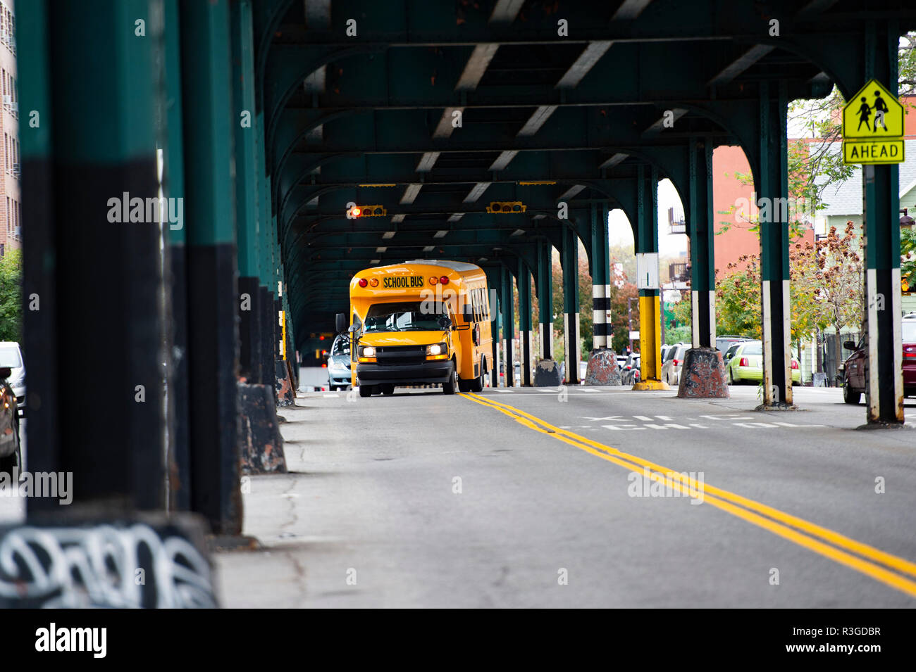 A school bus is passing under the railway bridge in the Bronx, New York ...