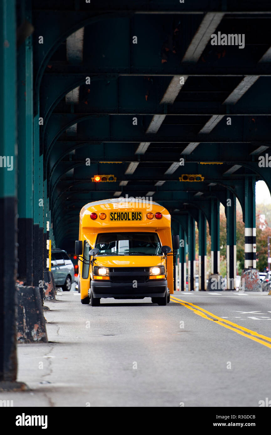 A school bus is passing under the railway bridge in the Bronx, New York ...