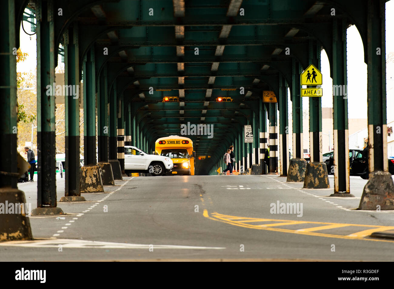 A school bus is passing under the railway bridge in the Bronx, New York ...