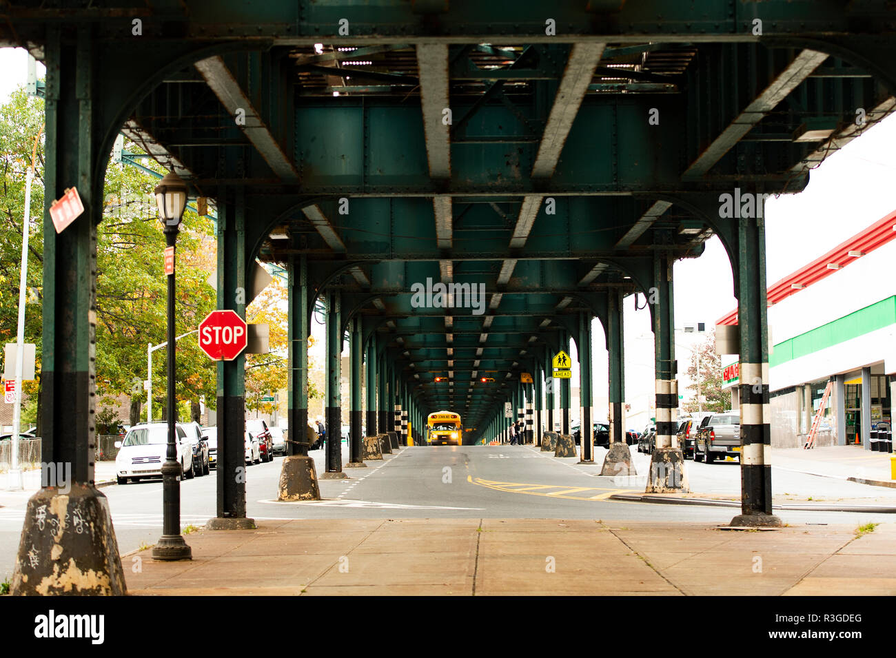 A school bus is passing under the railway bridge in the Bronx, New York ...