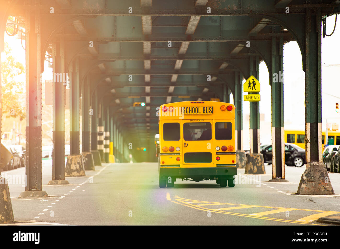 A school bus is passing under the railway bridge in the Bronx, New York ...
