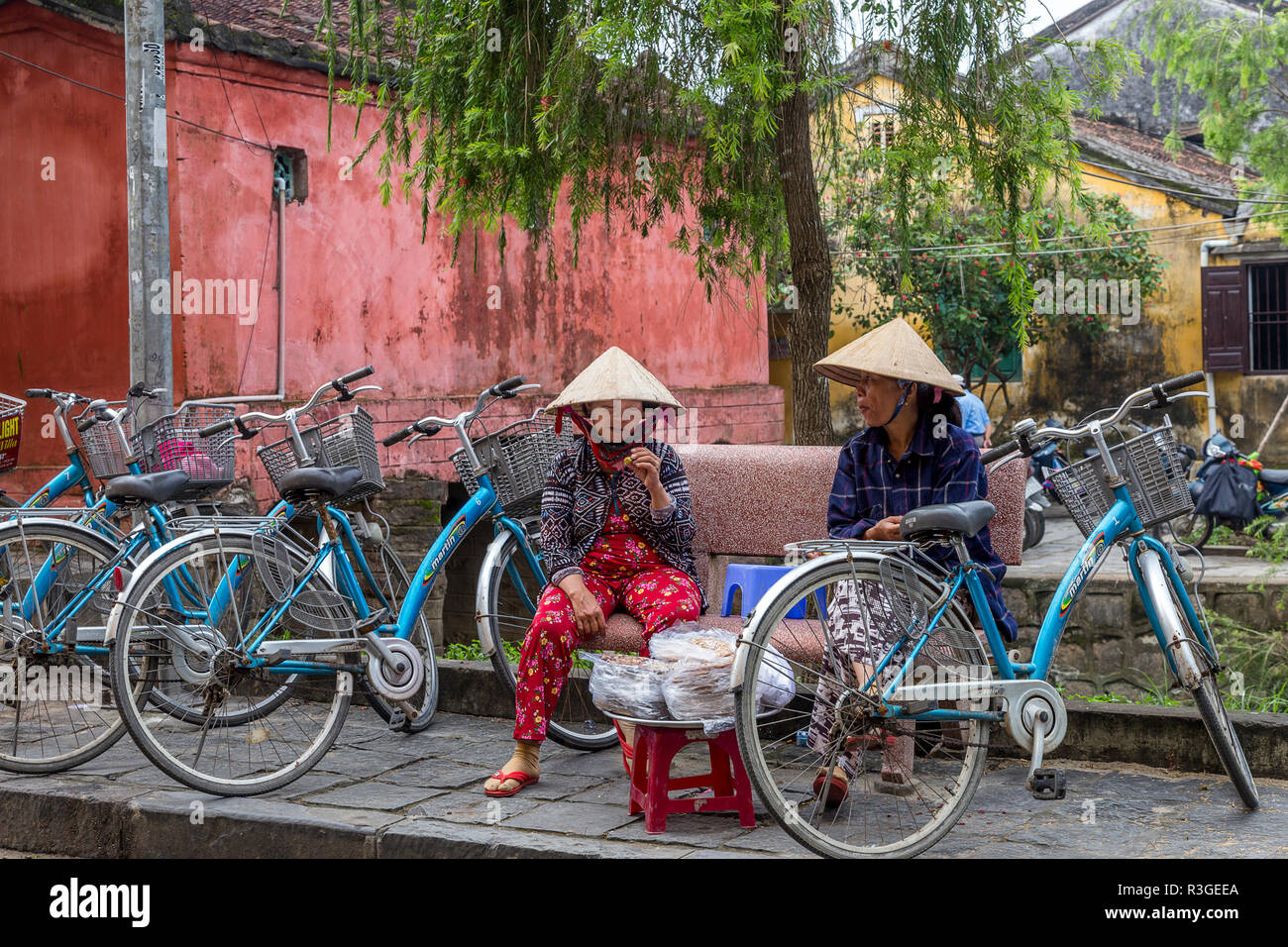 Two Vietnamese women sitting and talking in Hoi An Old Town while ...