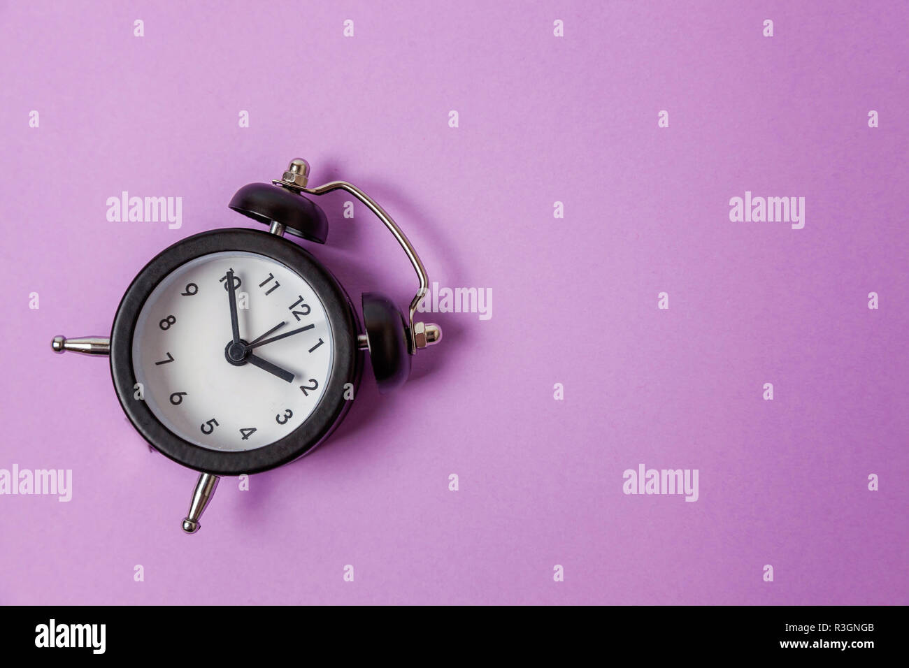 Ringing twin bell vintage classic alarm clock Isolated on purple violet ...