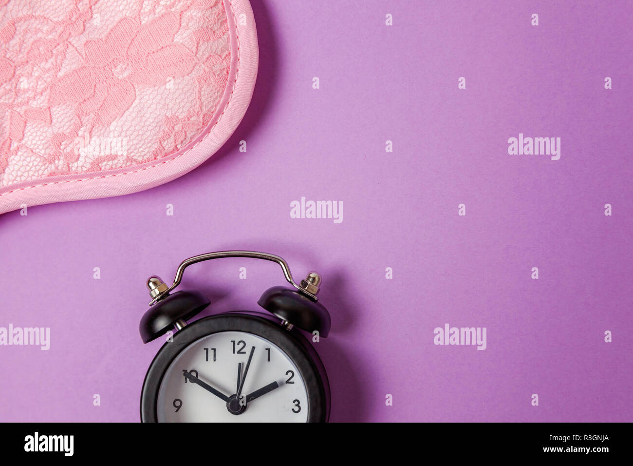 Sleeping eye mask, alarm clock isolated on purple violet pastel ...