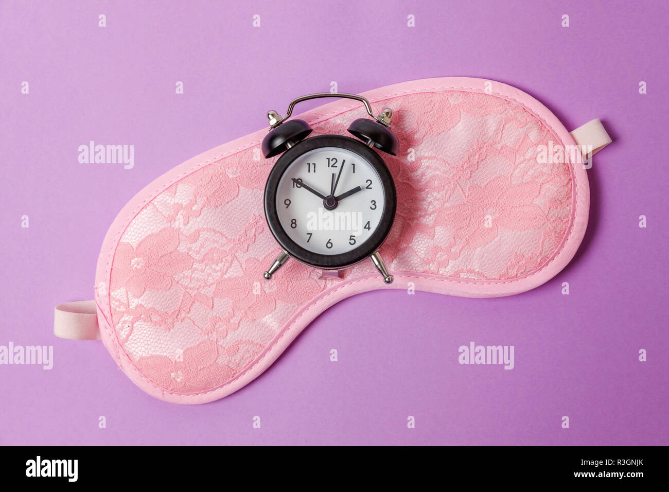 Sleeping eye mask, alarm clock isolated on purple violet pastel ...