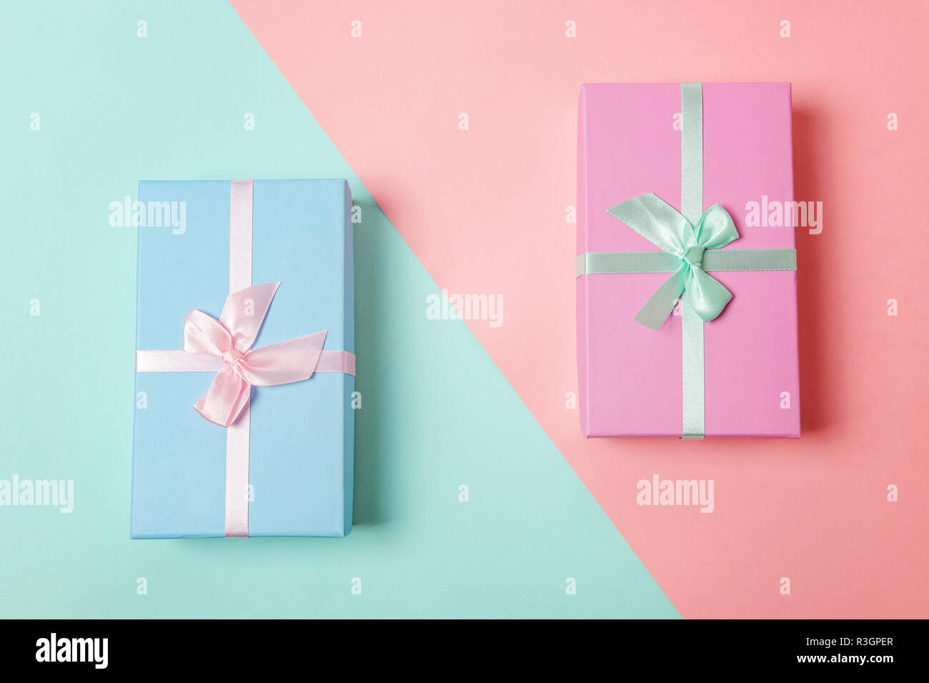 Small gift box wrapped pink and blue paper isolated on blue and pink ...