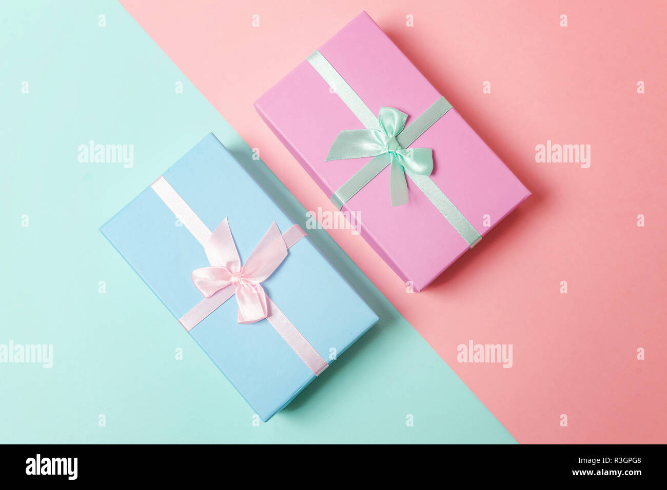 Small gift box wrapped pink and blue paper isolated on blue and pink ...