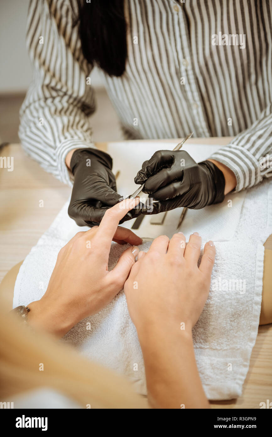 Manicure master feeling busy while making manicure for her client Stock ...