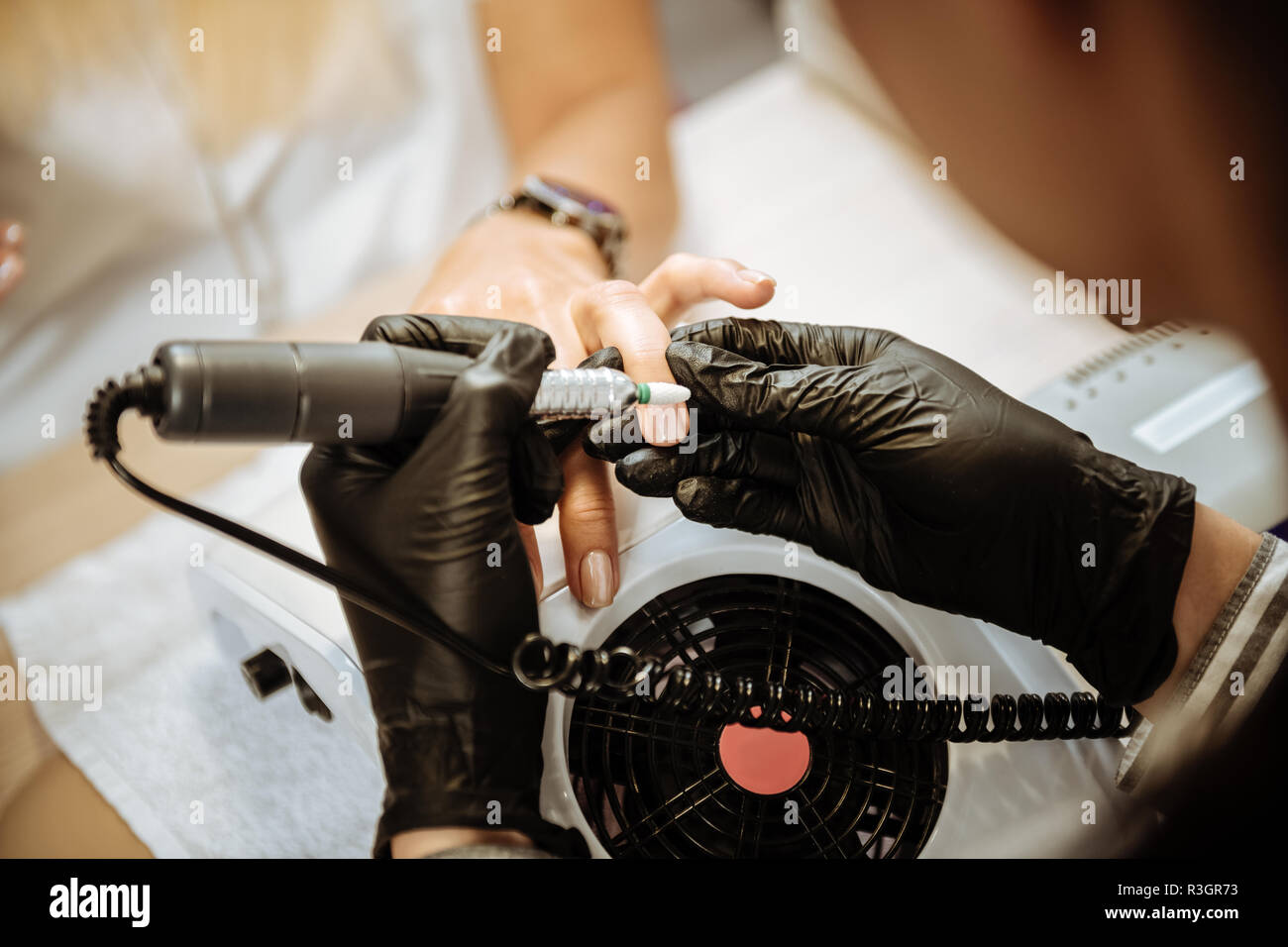 Professional nail artist making machine manicure and polishing nails ...