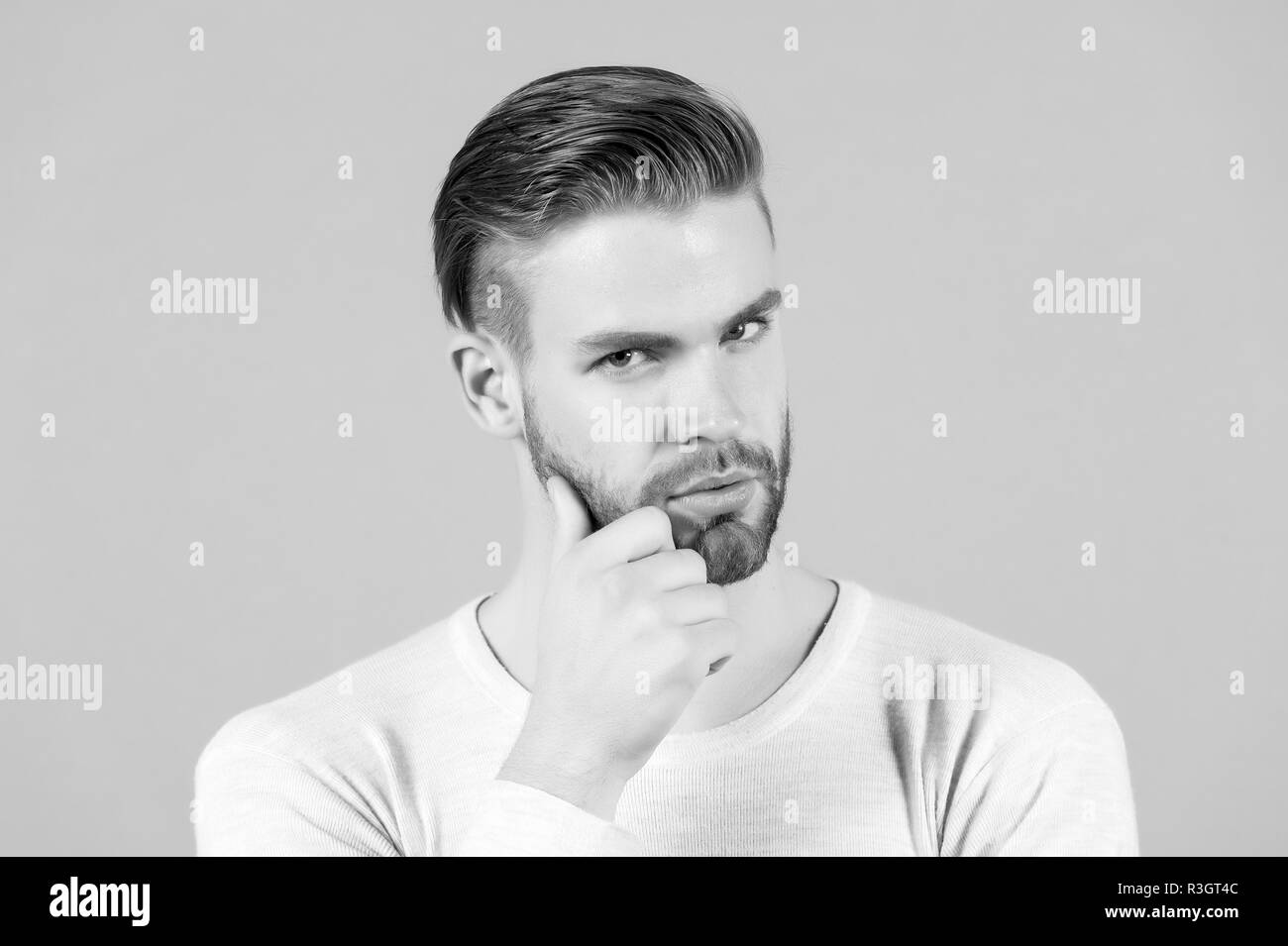 Bearded man touch beard with hand. Macho with stylish hair and healthy ...