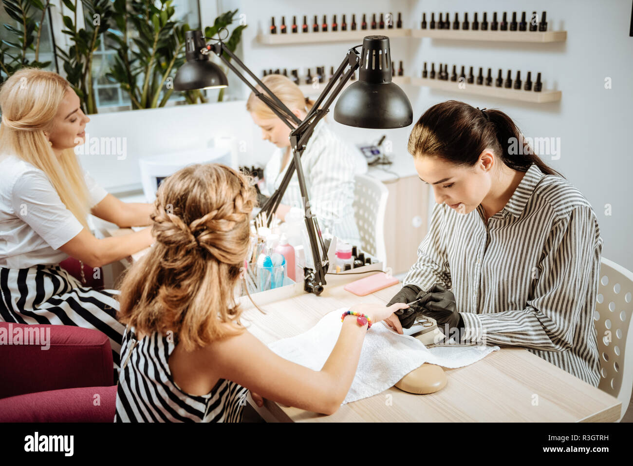 Mother and daughter coming to beauty saloon and having manicure Stock ...