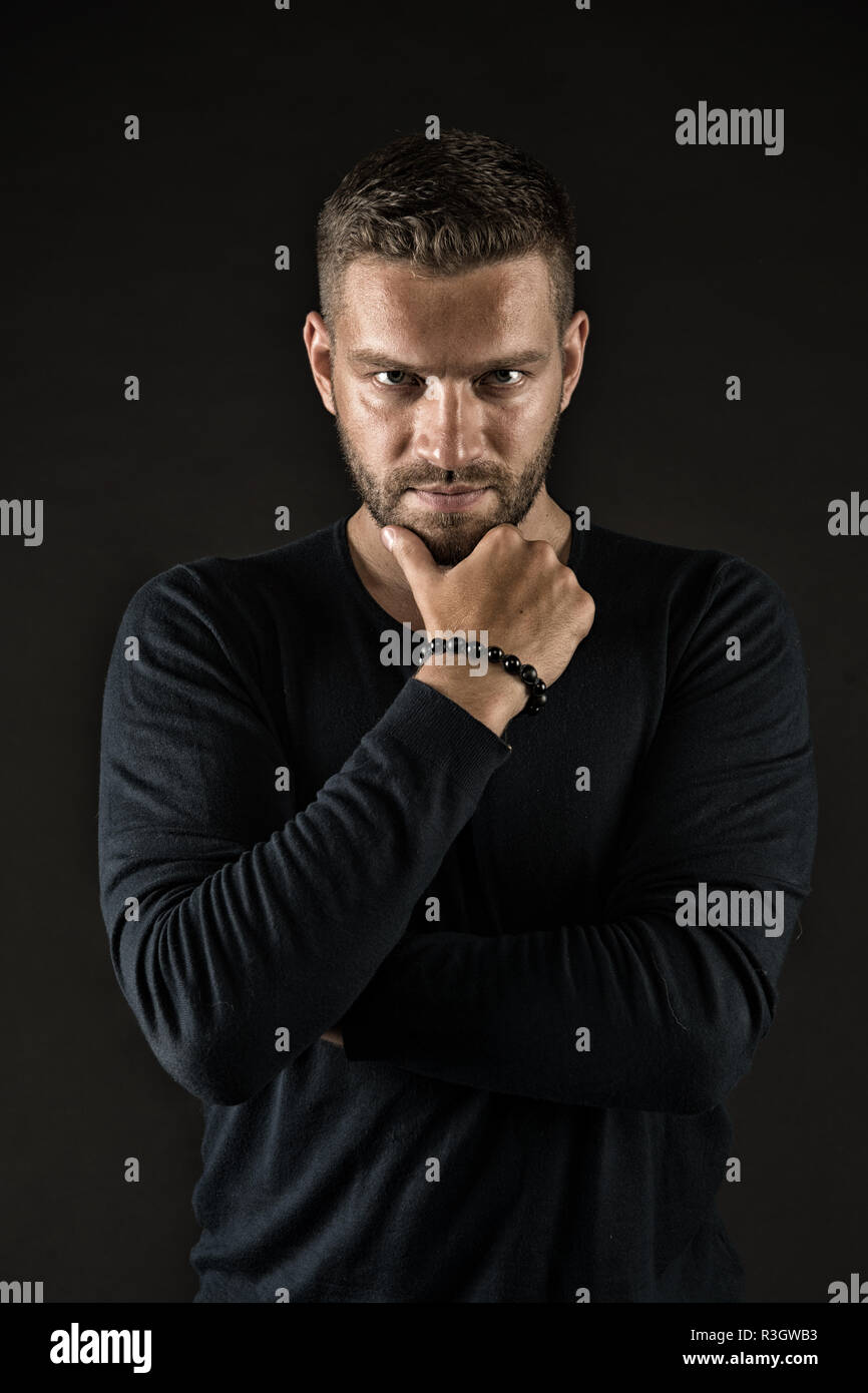 Man with evil look isolated on dark background. Macho touching his ...