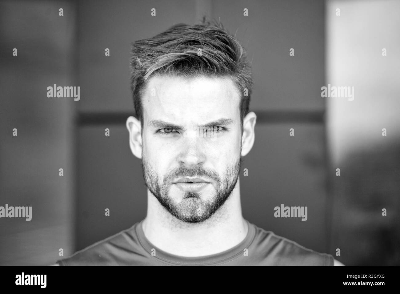 Man with bristle on strict face, urban background. Man with beard or ...