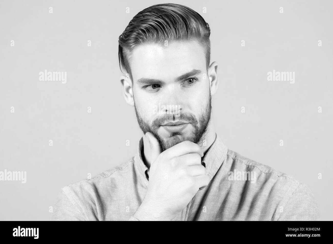 Macho with stylish hair touch beard with hand. Bearded man with healthy ...