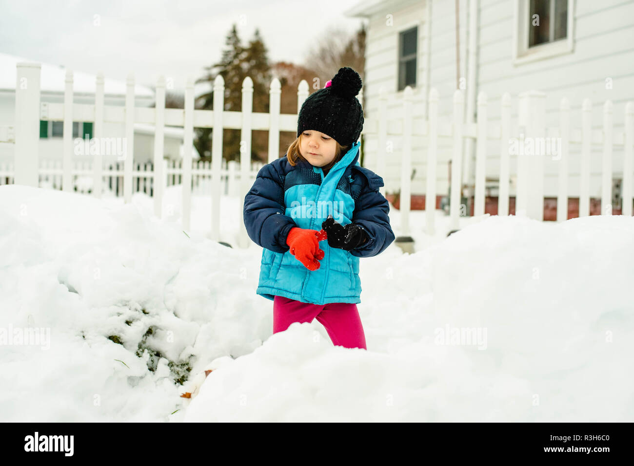 A little girl plays in the snow on a cold winter day in the United ...