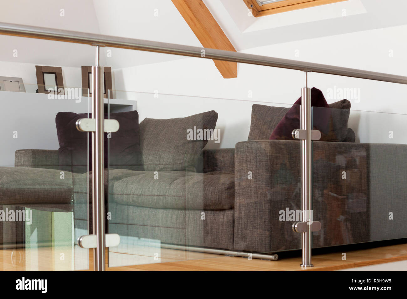 living room with gray sofa behind a glass railing Stock Photo - Alamy