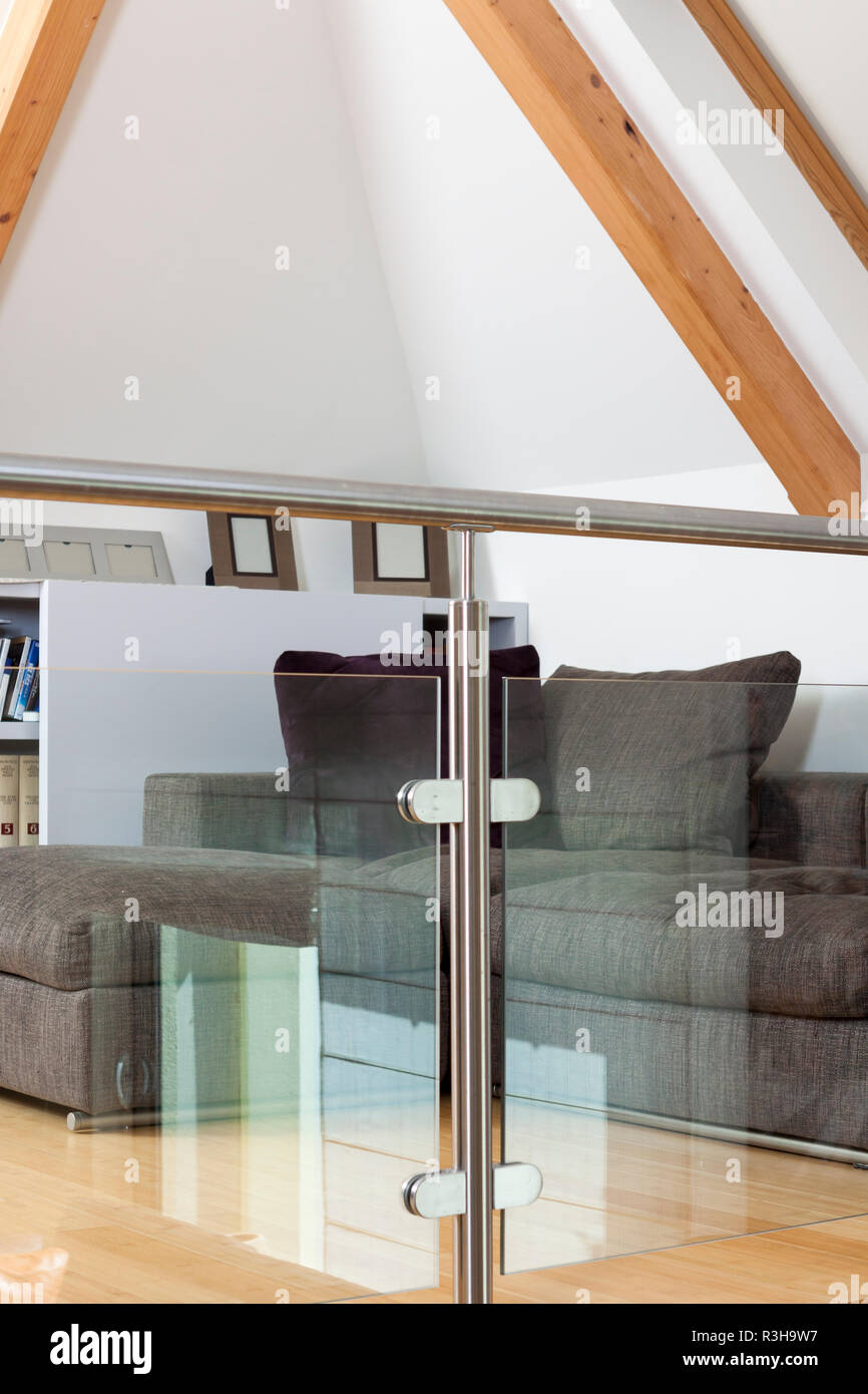 living room with gray sofa behind a glass railing Stock Photo - Alamy