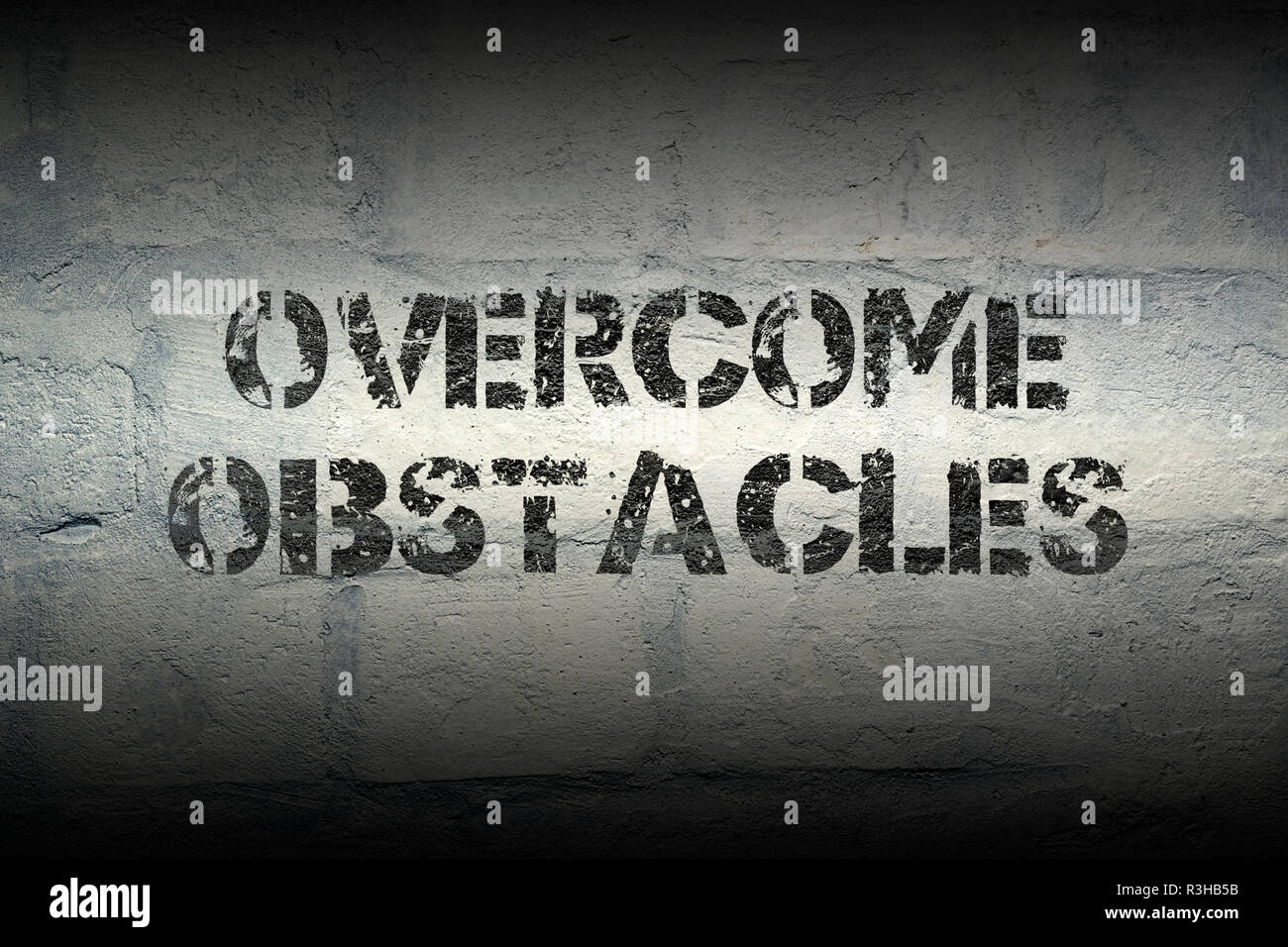 overcome obstacles stencil print on the grunge white brick wall Stock ...