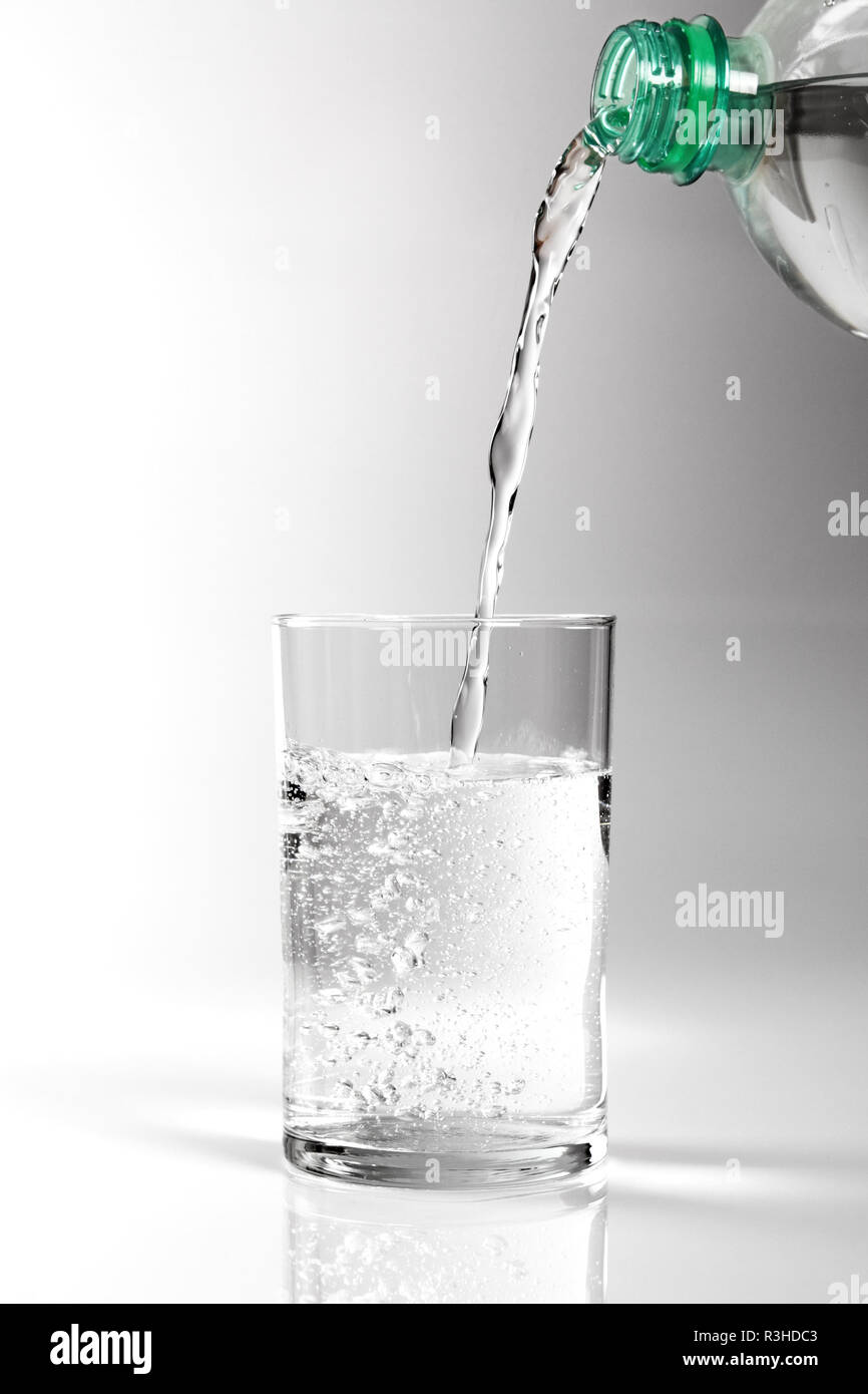 Pouring clear water into glass. Isolated on white background Stock Photo - Alamy