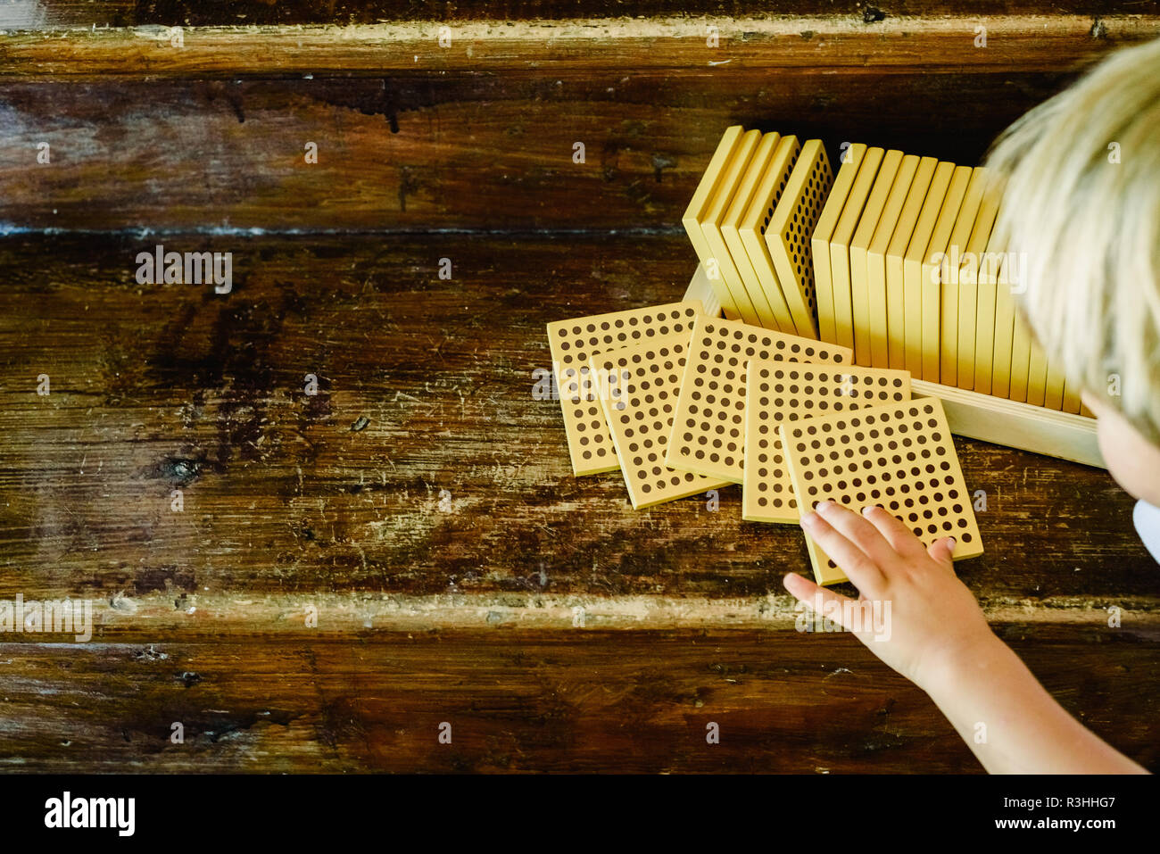 Hands of boy manipulating counting cubes on wooden background in ...